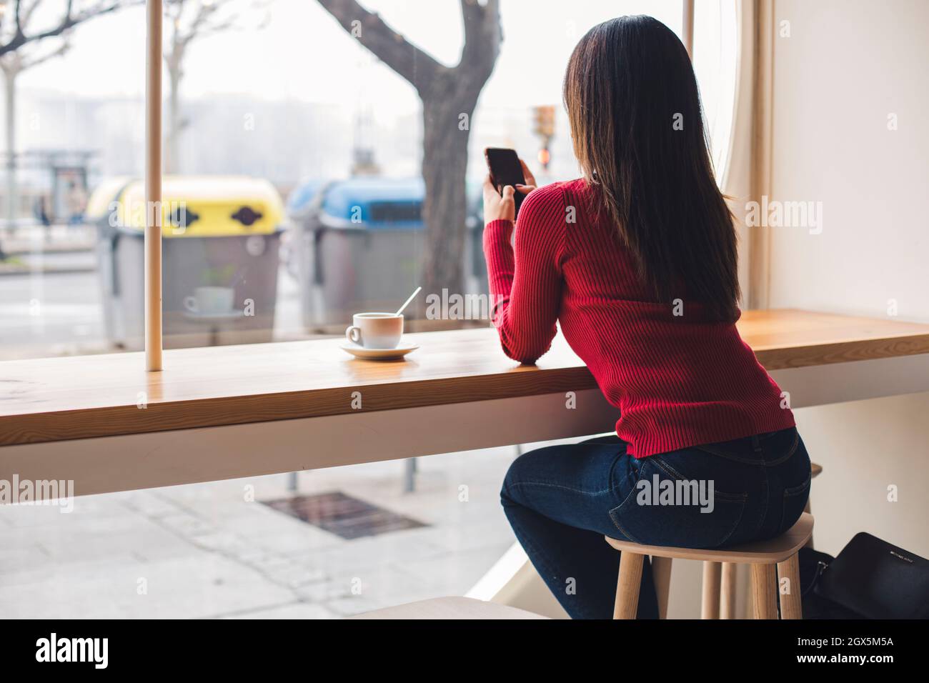 Girl typing a message on her mobile phone while having a coffee Stock ...
