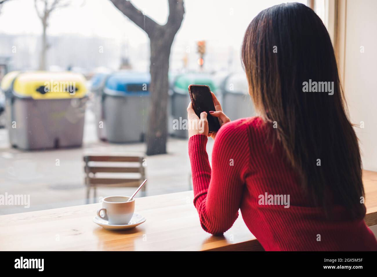 Girl typing a message on her mobile phone while having a coffee Stock ...