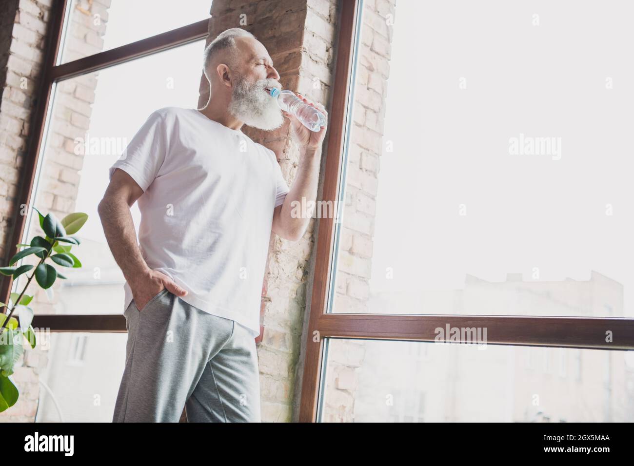 Photo of mature positive good mood smiling man drinking water hydrating ...