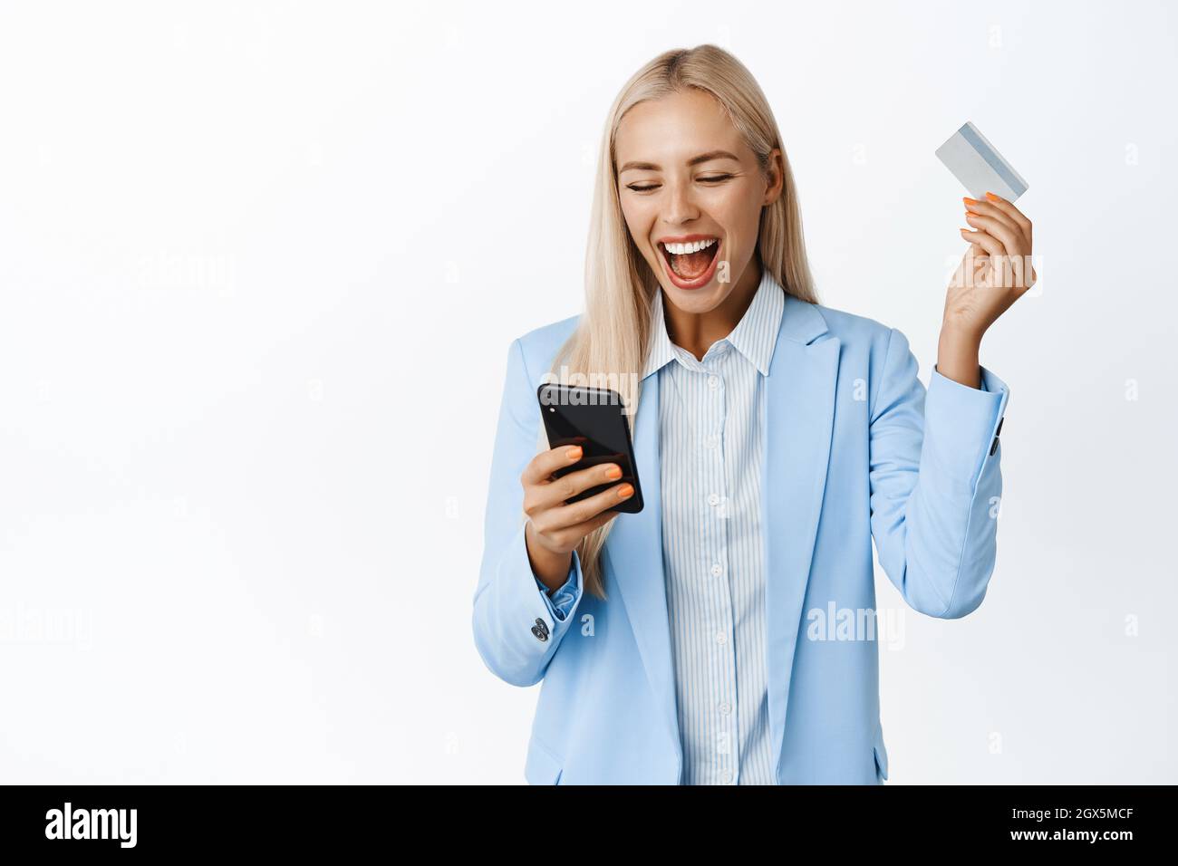 Enthusiastic saleswoman cheering with credit card, laughing and smiling ...