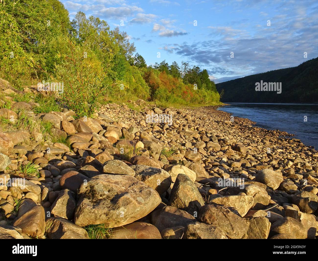 Rocky river bank with large cobblestones, in the sunset light. Tsipa ...