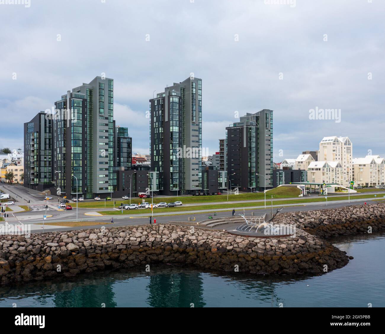 Modern high rise buildings located near road and calm water against ...