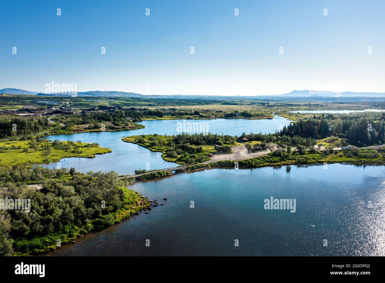 Drone view of clean river flowing between green shores connected with ...