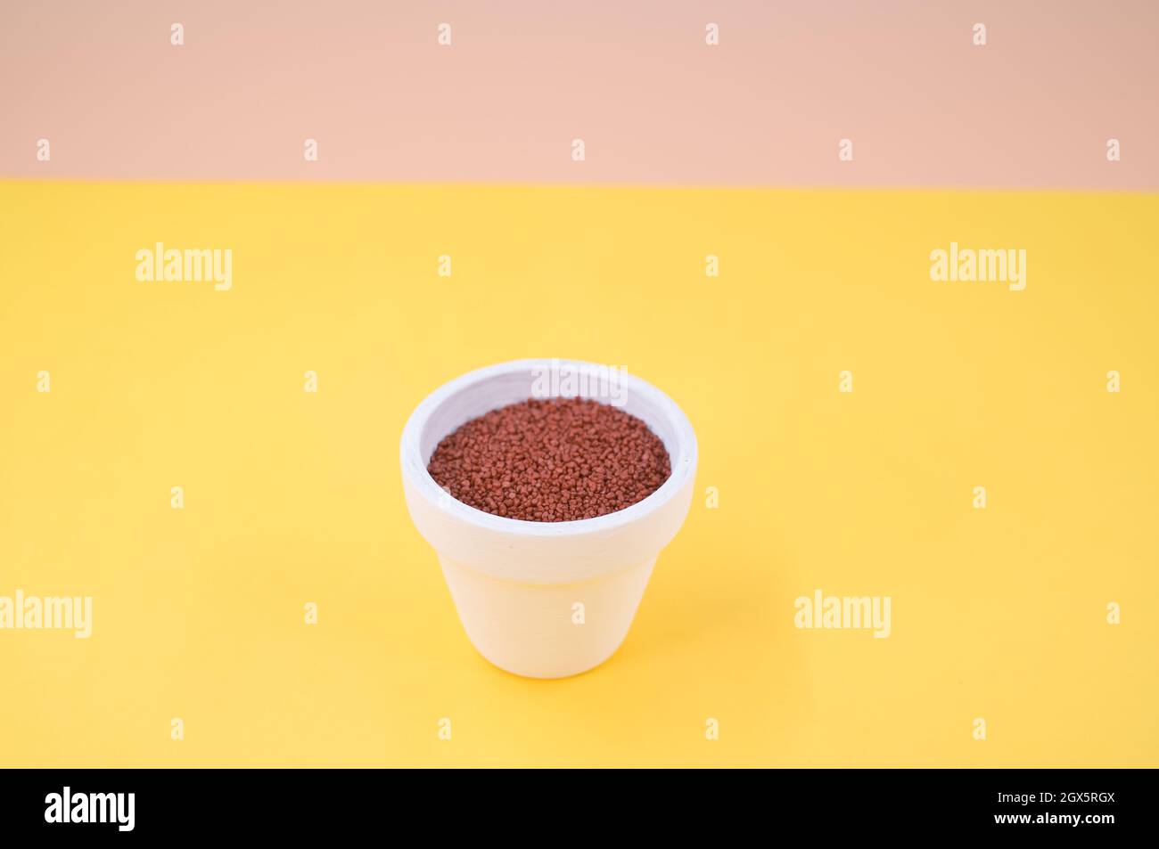 decorative orange colored sand in a white vase Stock Photo - Alamy