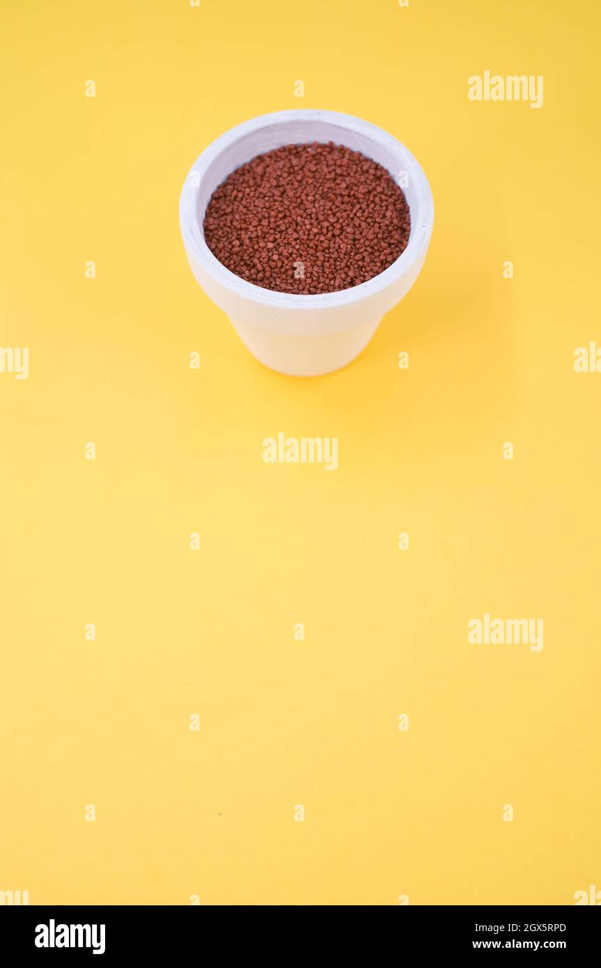 decorative orange colored sand in a white vase Stock Photo - Alamy