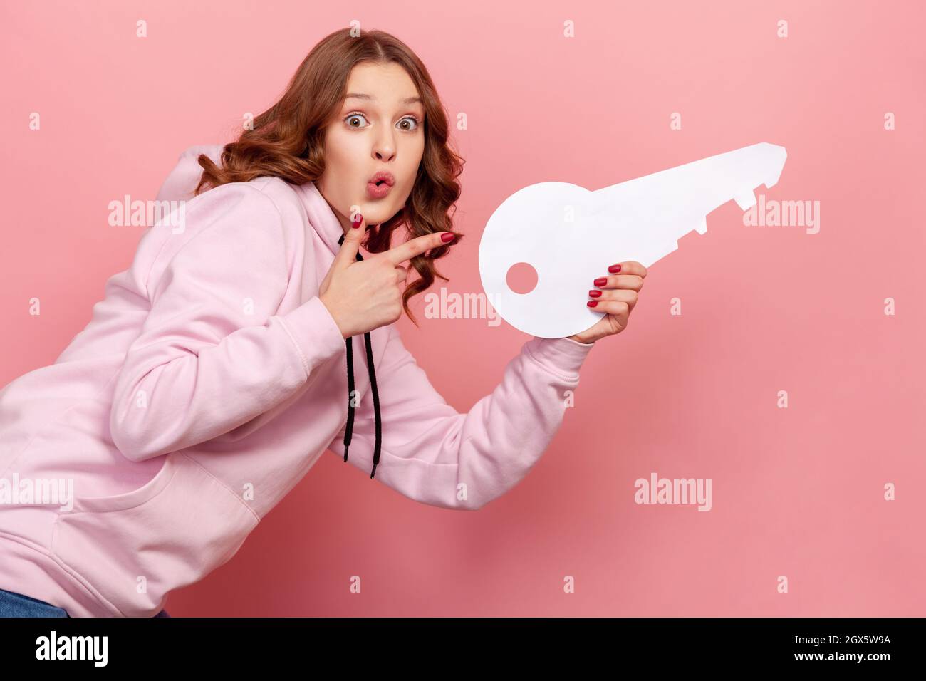 Side view portrait of curly haired teenage girl in hoodie with pout ...