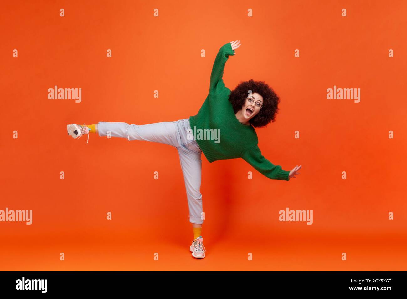 Full length portrait of amazed excited woman with Afro hairstyle in green casual sweater ...