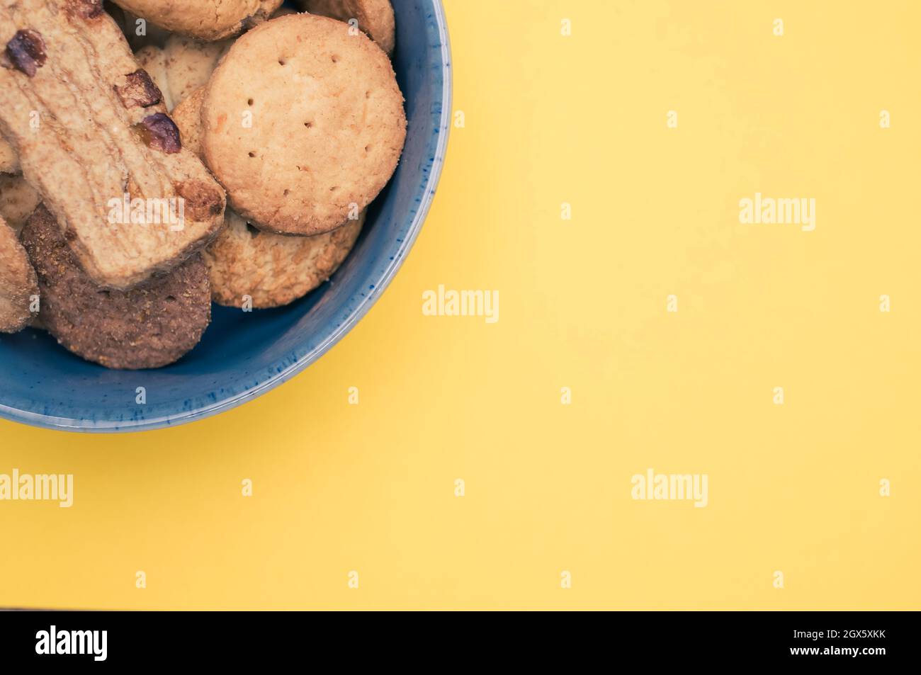Organic biscuits in a bowl on a yellow paper background with copy space ...