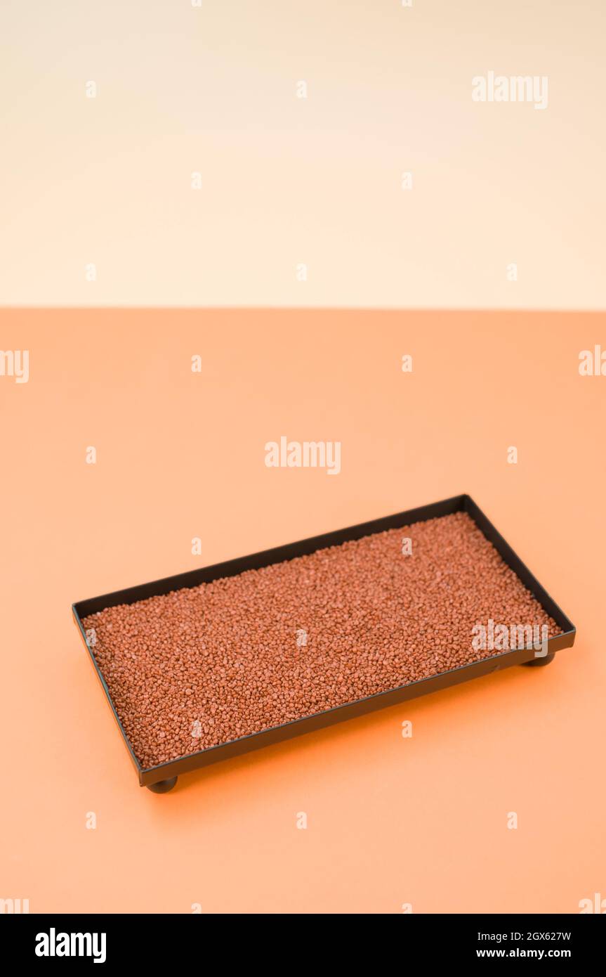 decorative orange colored sand in a metal box Stock Photo - Alamy
