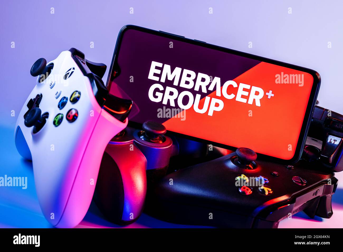 A smartphone with the Embracer Group logo on the screen on the pile of ...