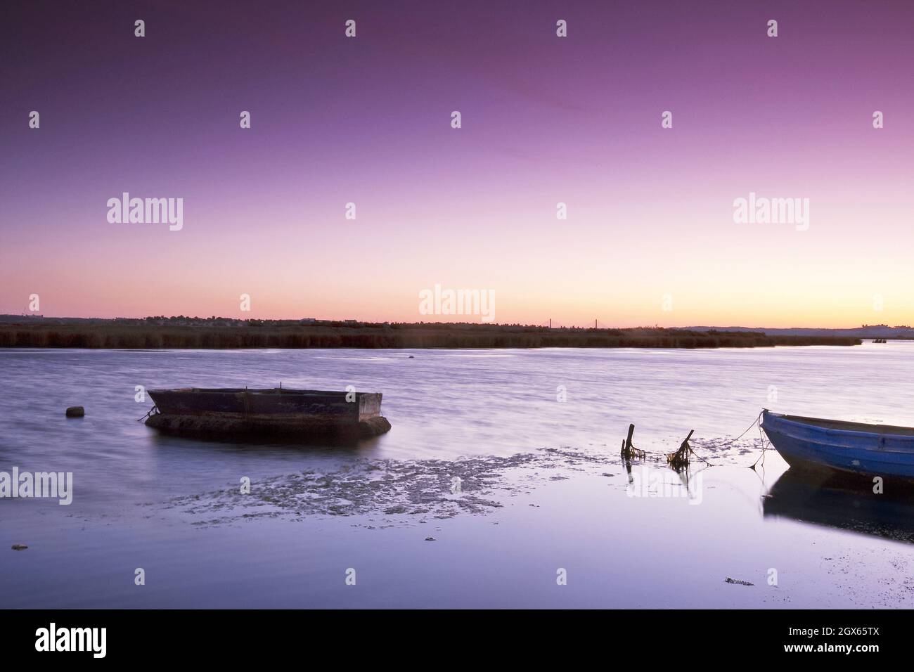 Scenic view of wooden boats on the beach during sunset in Portugal ...