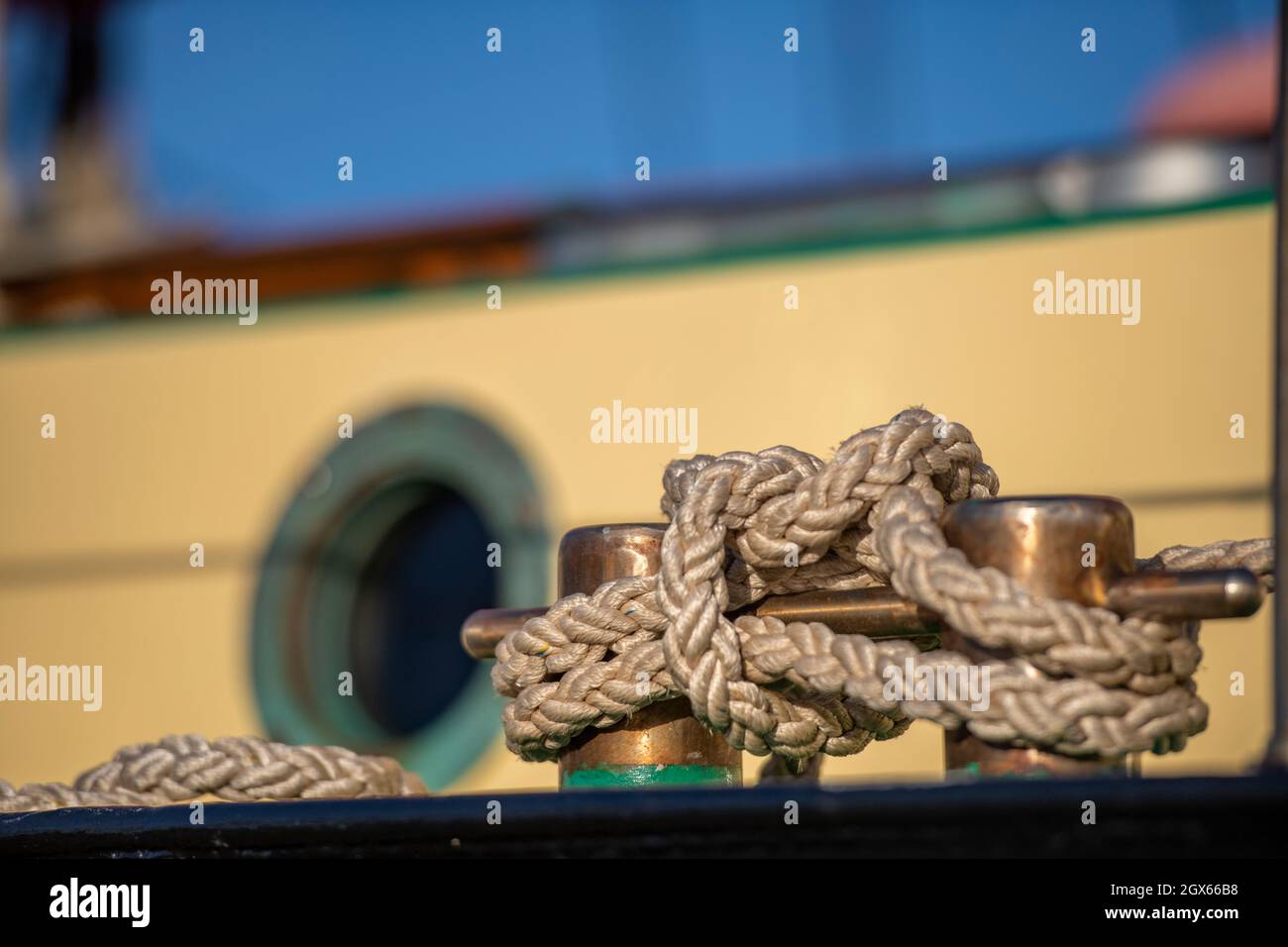 brass bollards on a ship or boat with a berthing rope or line hawser ...