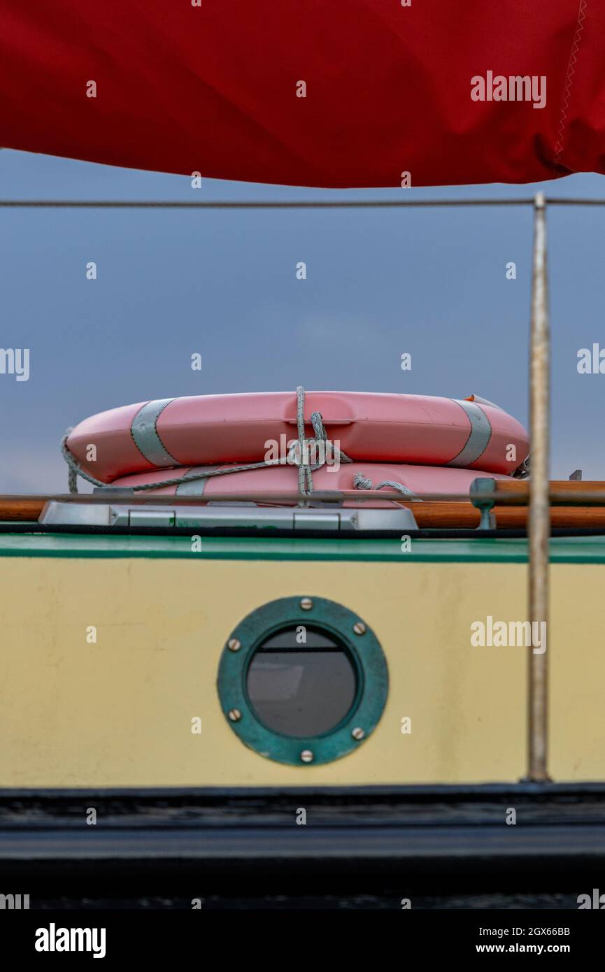 close-up of porthole and two orange life rings or perry buoys on a ...