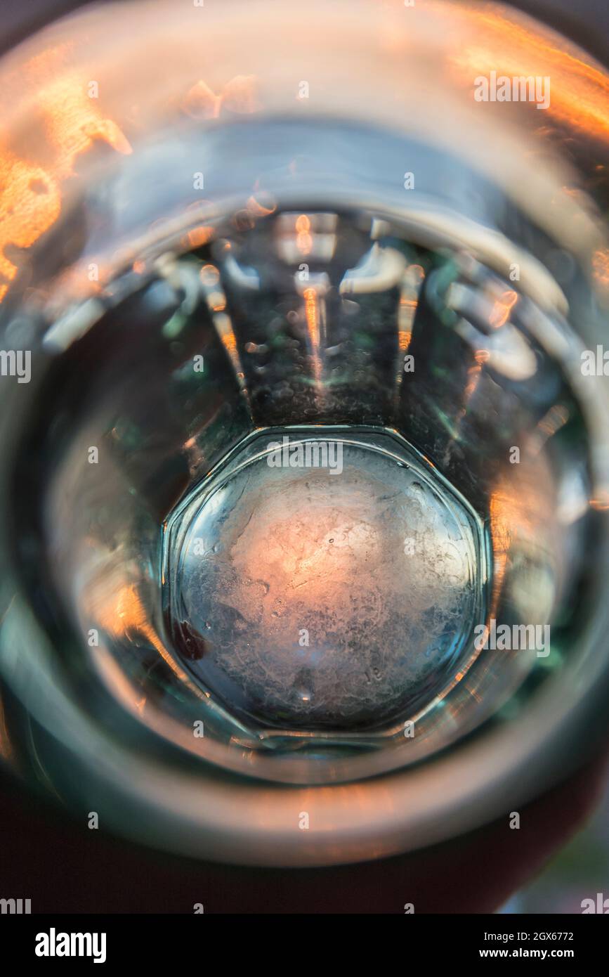 Looking at the bottom of an empty glass with sunlight reflections Stock ...