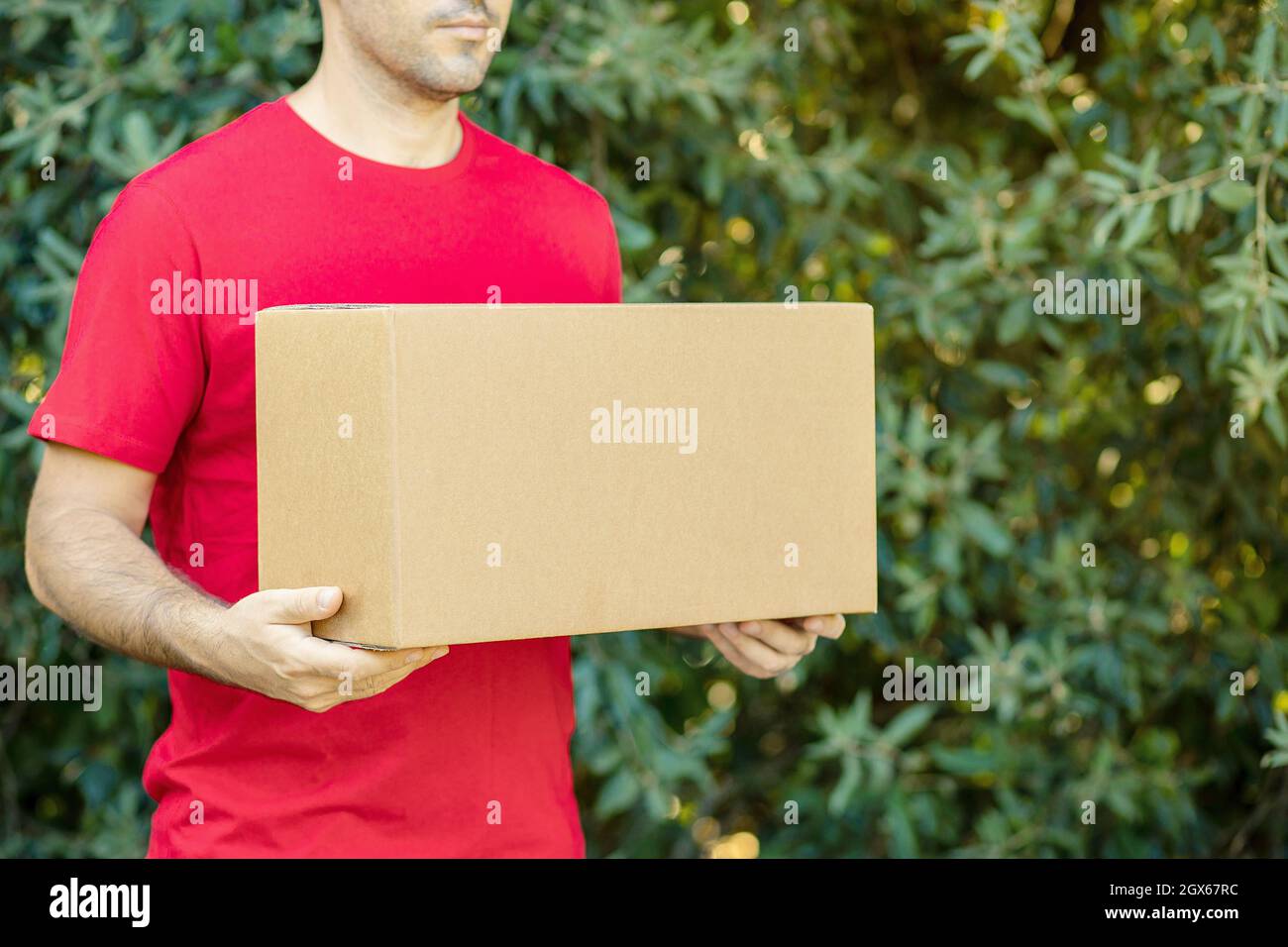 Delivery man holding cardboard boxes on the farm. Express delivery ...