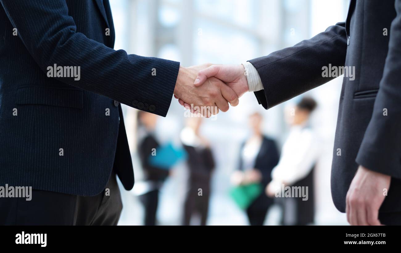 Close-up handshake of business people in front of colleagues team Stock ...