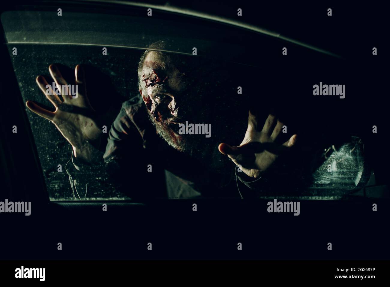 Zombie male attack car driver through vehicle window glass halloween ...
