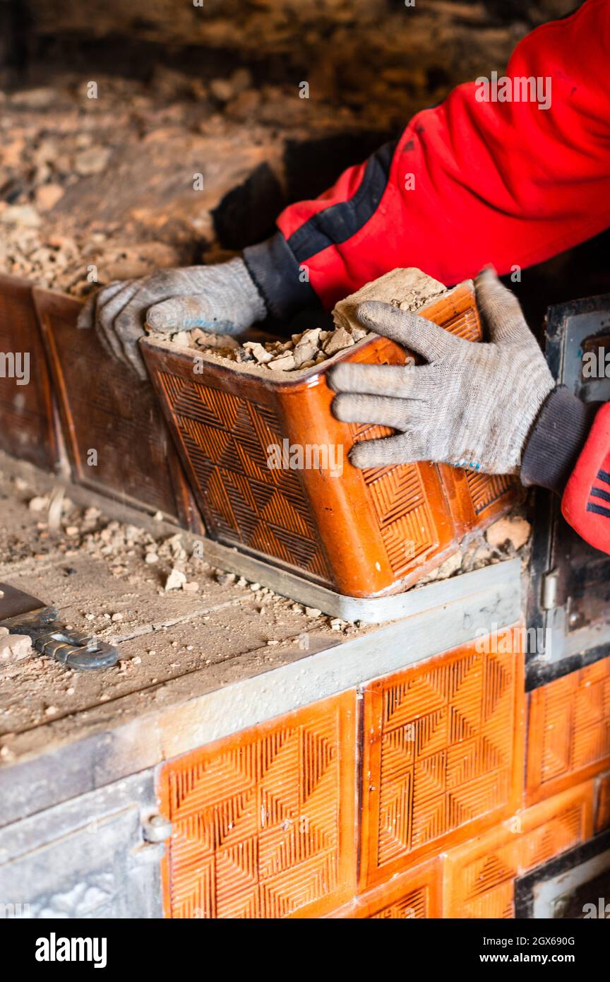 An old brick stove, brick in soot, dismantling the old kitchen with his ...