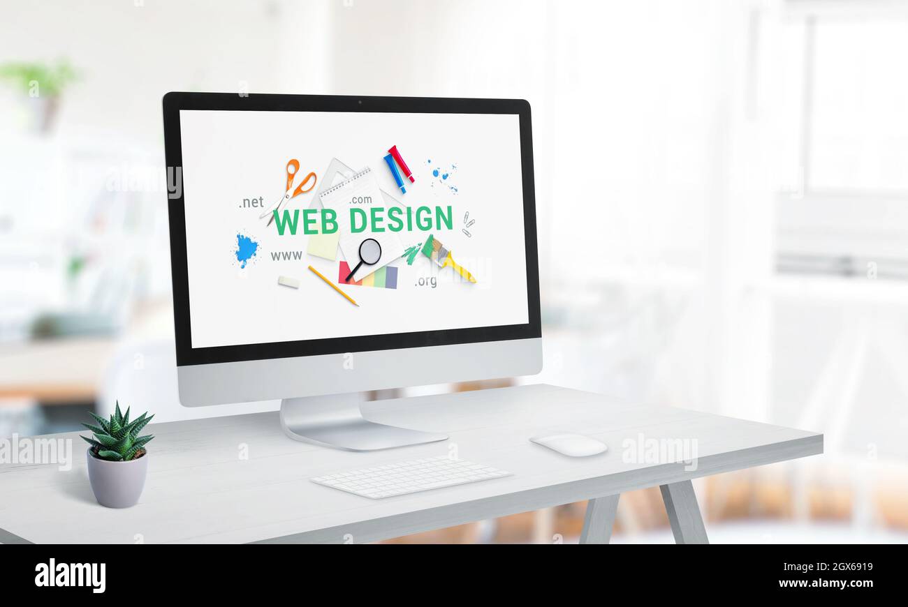 Web design studio with computer display on office desk. Creative web page with web design text ...