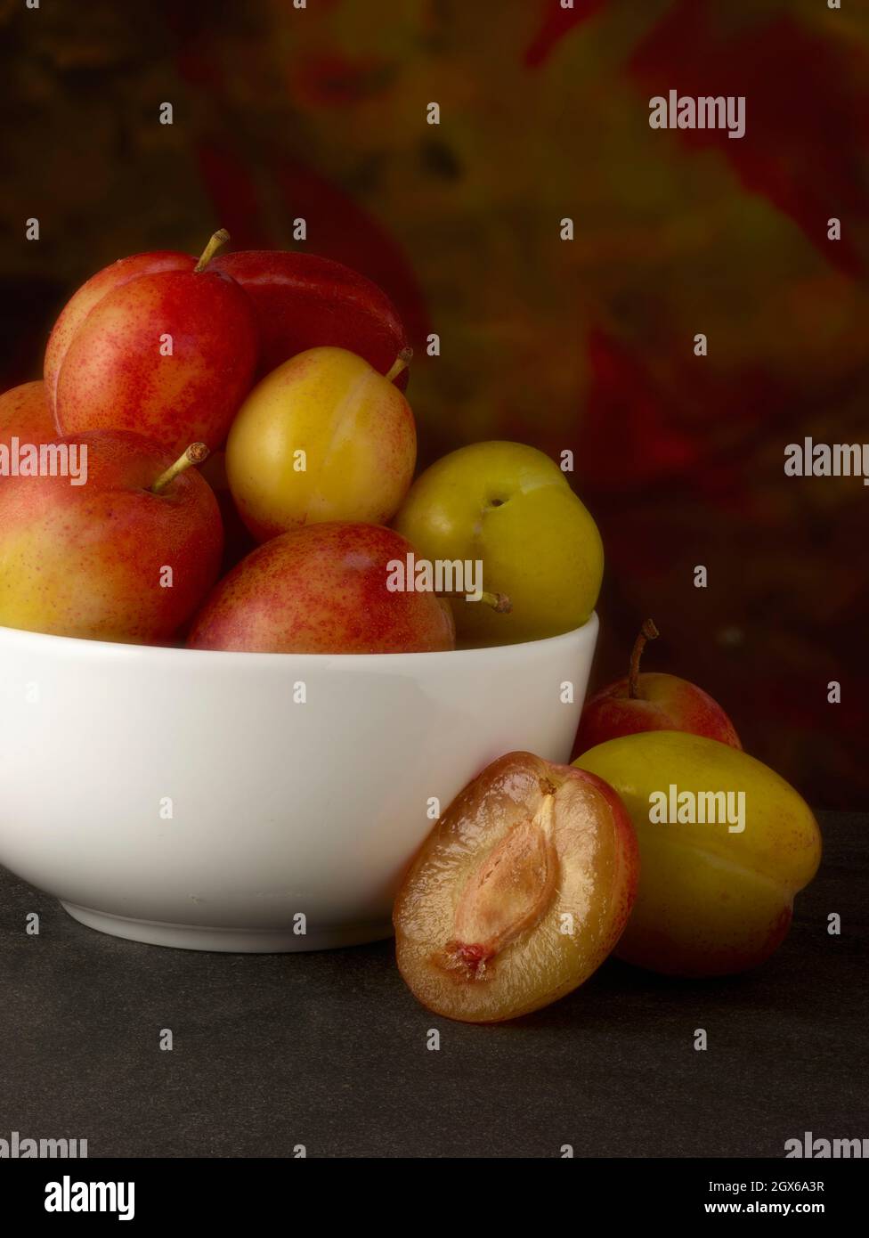 Market fresh sweet plums, natural food still life against plain ...