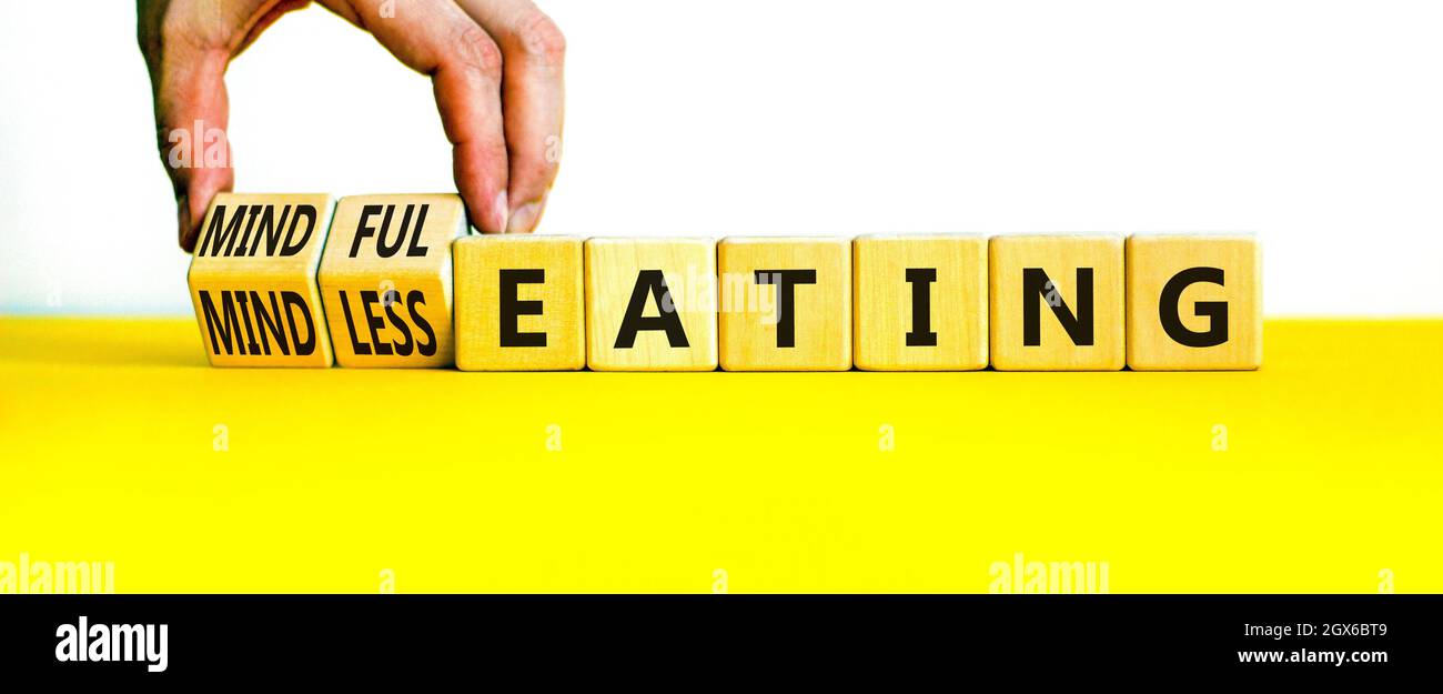 Mindful or mindless eating symbol. Doctor turns cubes and changes words ...