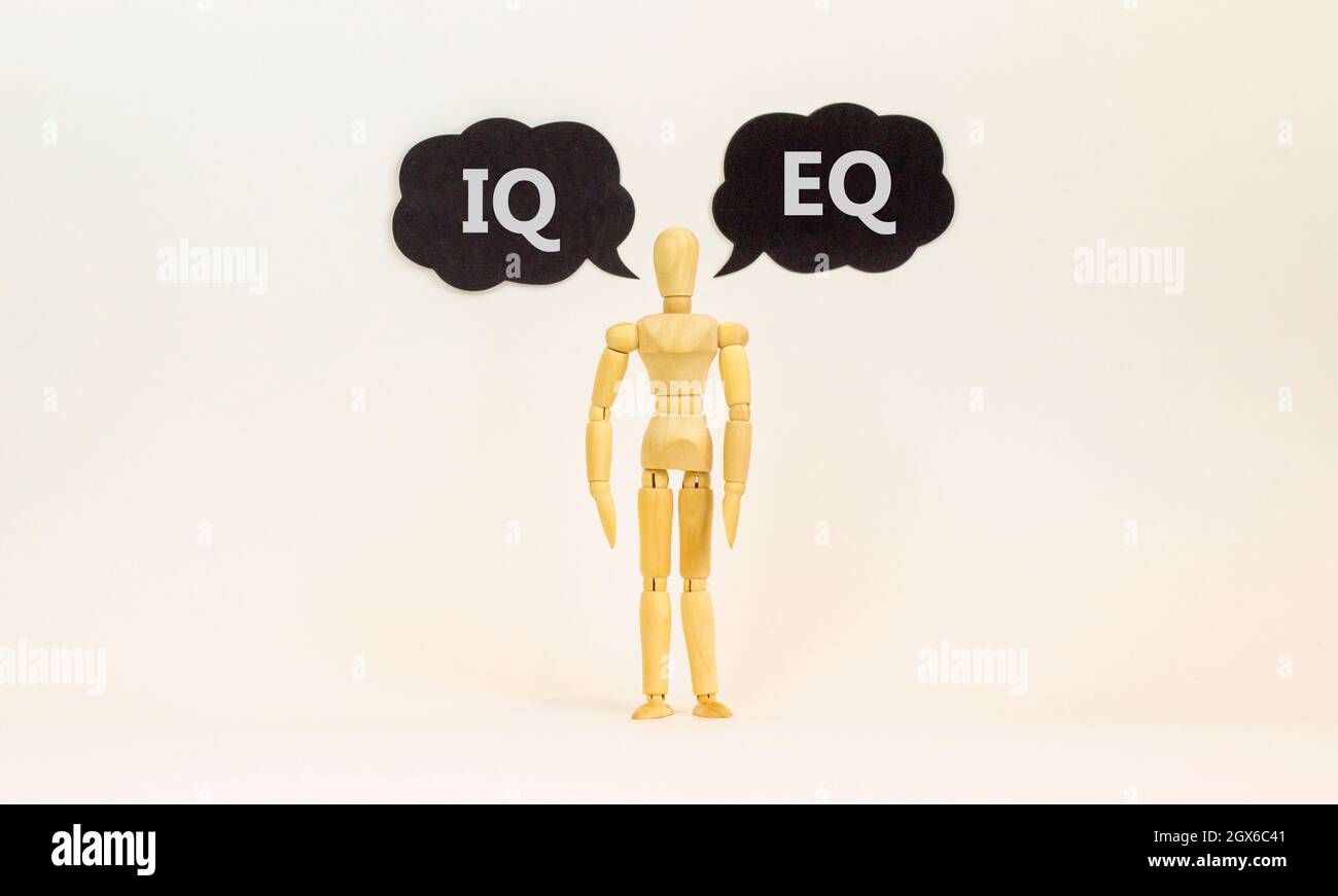 IQ or EQ symbol. Wooden model of businessman human. Black paper. Words ...