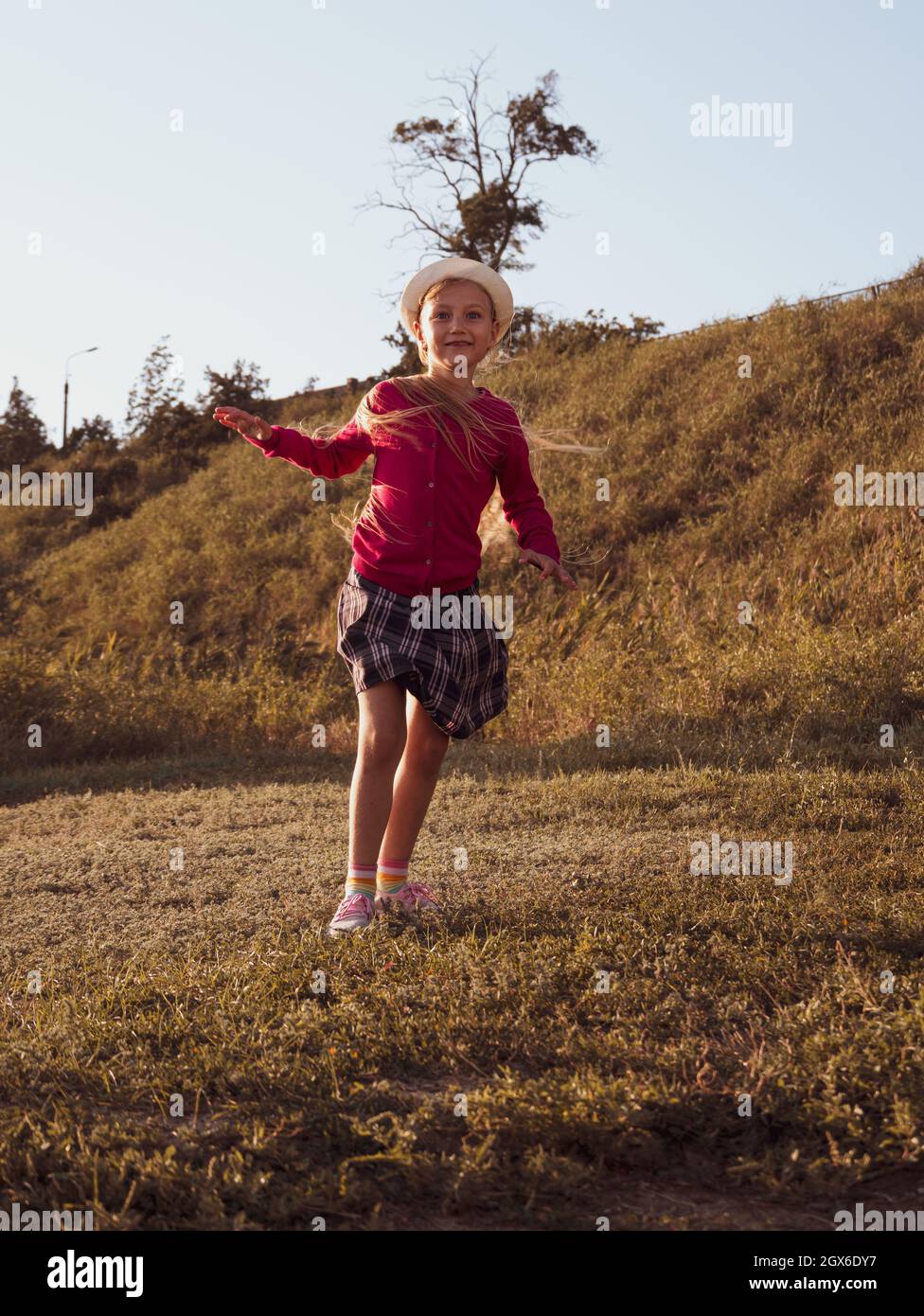 Happy little girl with long hair portrait jumping on nature background ...