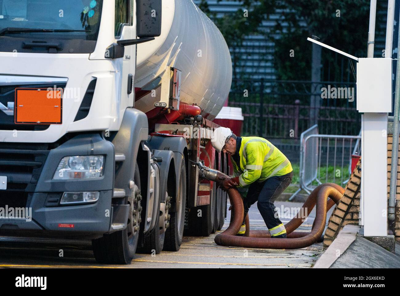 A tanker driver makes a fuel delivery at a petrol station in south ...