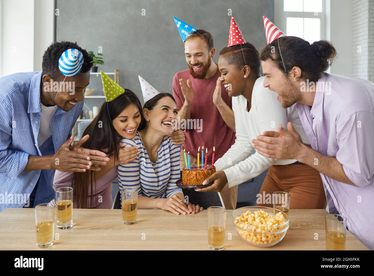 Caucasian young woman celebrates her birthday surrounded by her ...