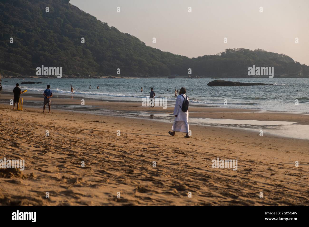 Man walking in waves on beach, Goa, India Stock Photo - Alamy