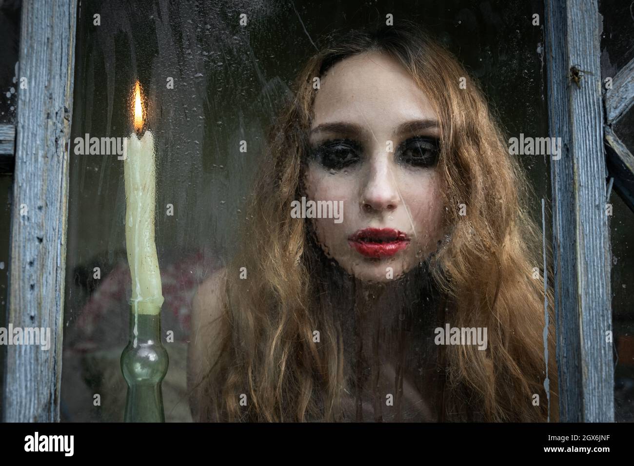 Beautiful Sad Young Girl Looking Out The Window With A Candle Good For