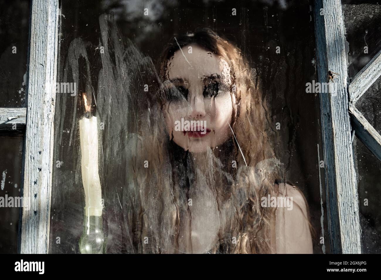 Beautiful Sad Young Girl Looking Out The Window With A Candle Good For