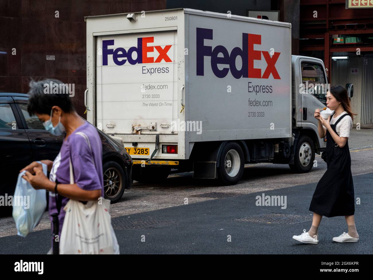 Pedestrians walk past the American FedEx Express delivery truck seen in ...