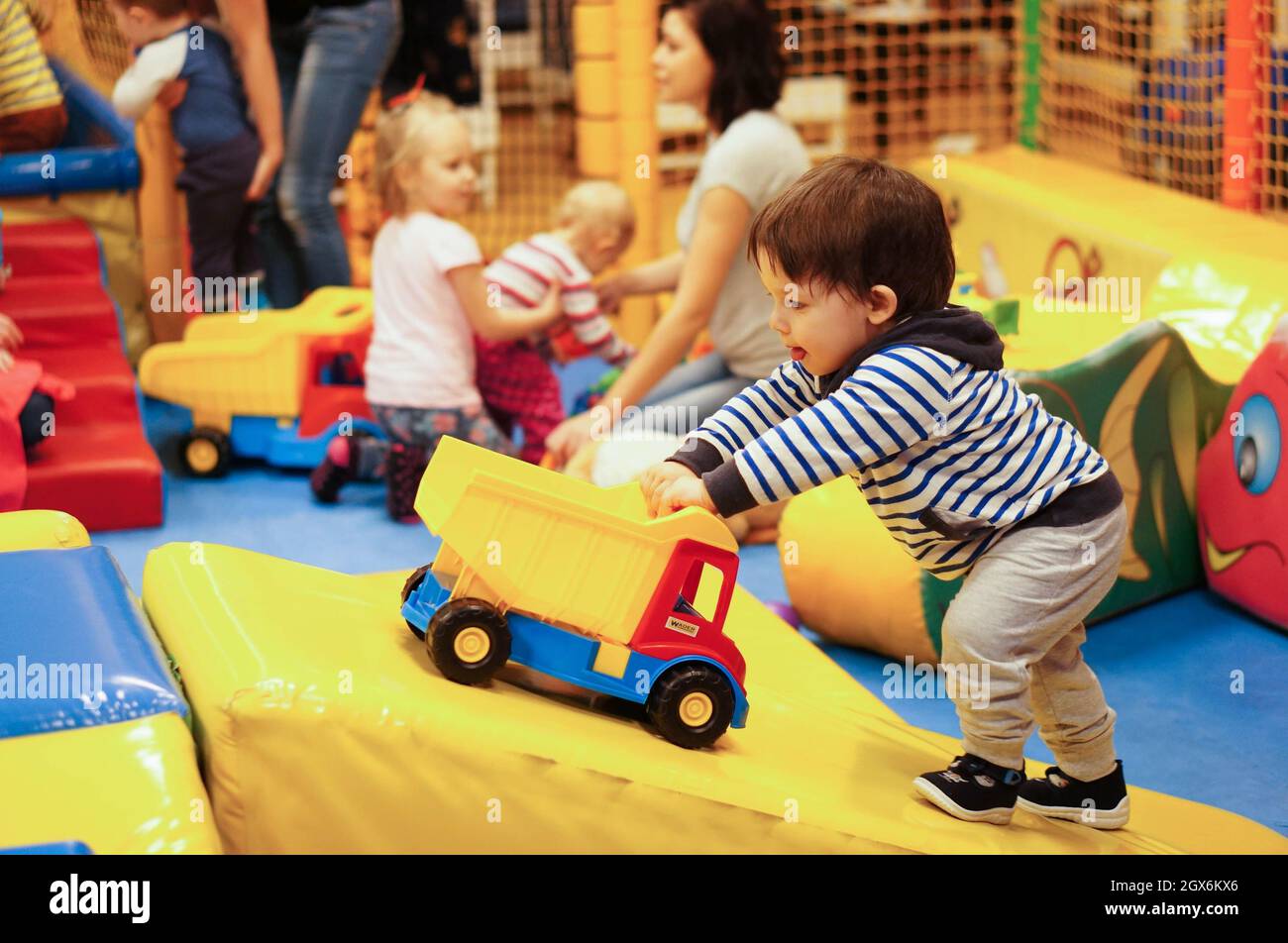 POZNAN, POLAND - Dec 11, 2015: A cute baby boy pushing a plastic toy ...