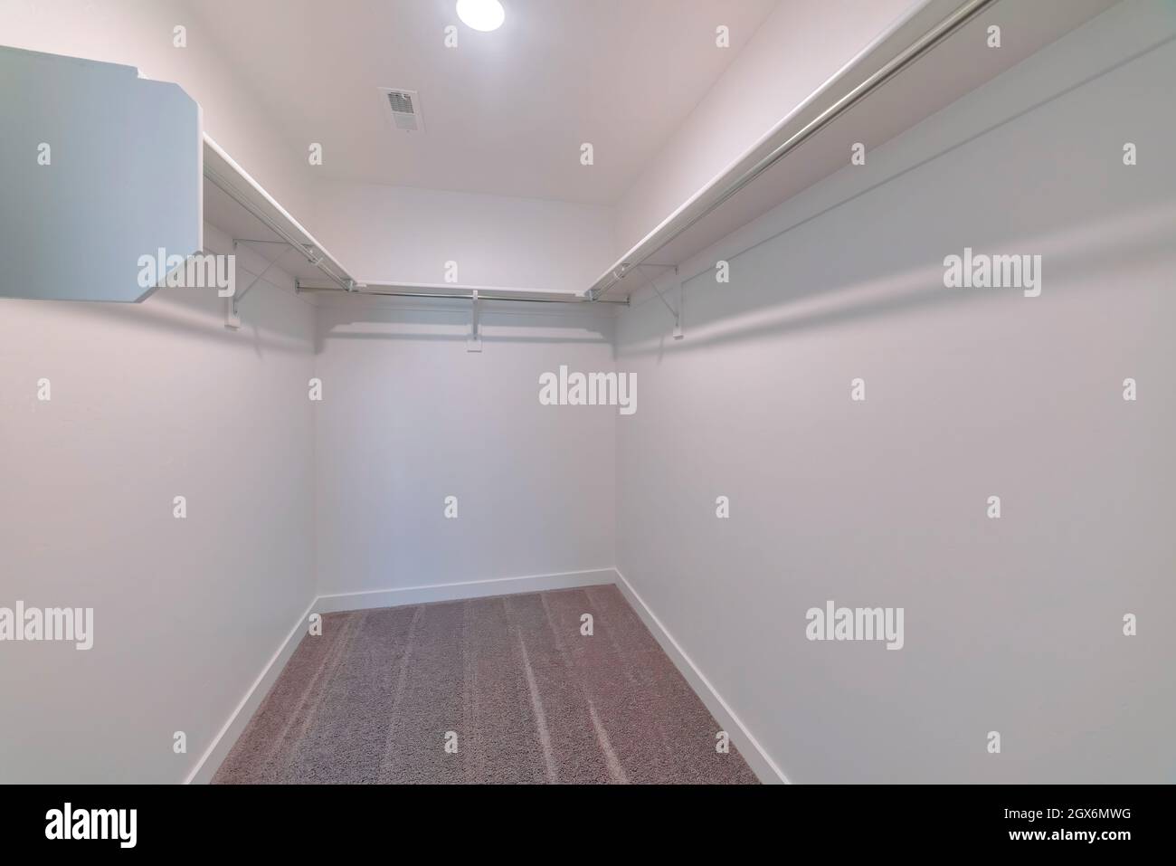 Image of an empty walk-in closet with white walls Stock Photo - Alamy