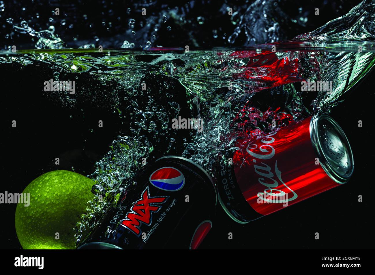 Close up view of can of coca cola, pepsi cola and apple falling into ...