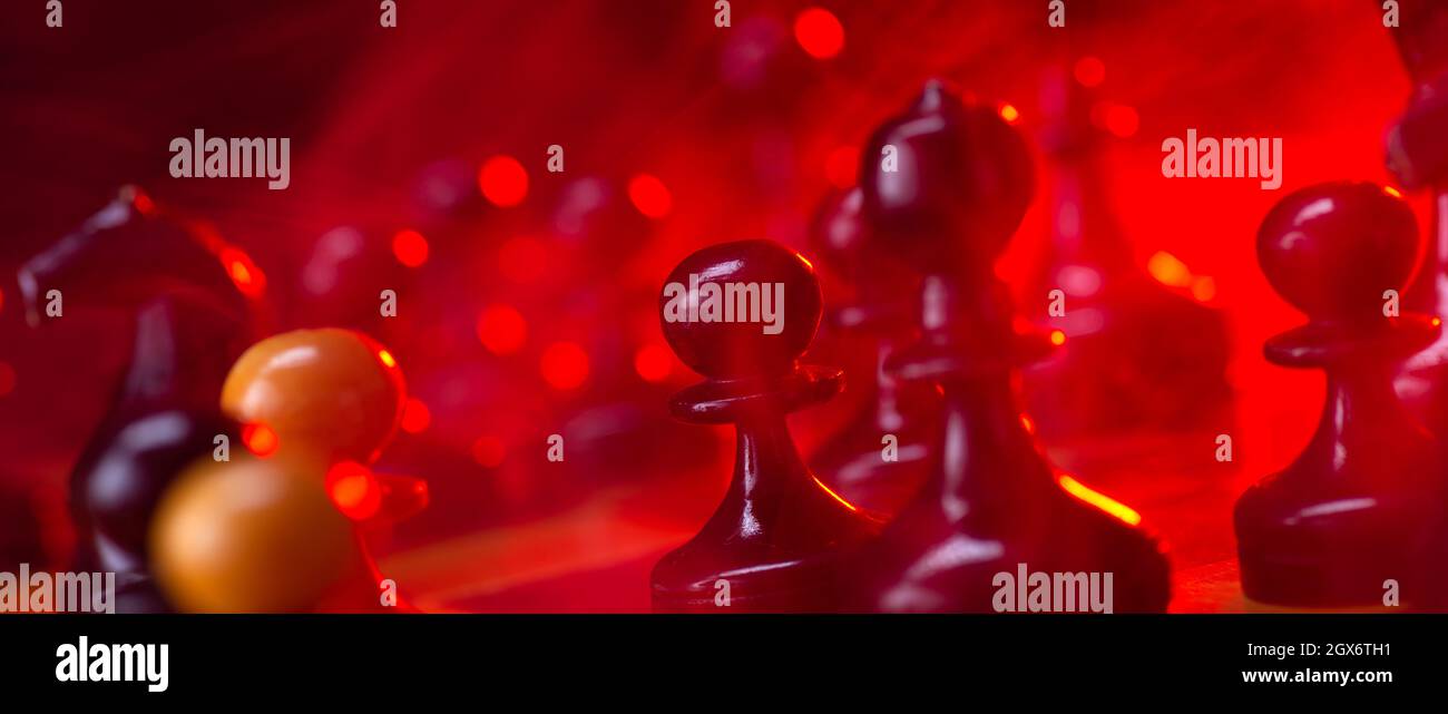Chess fight, chess pieces on the board, toned in red. Battle fire and ...