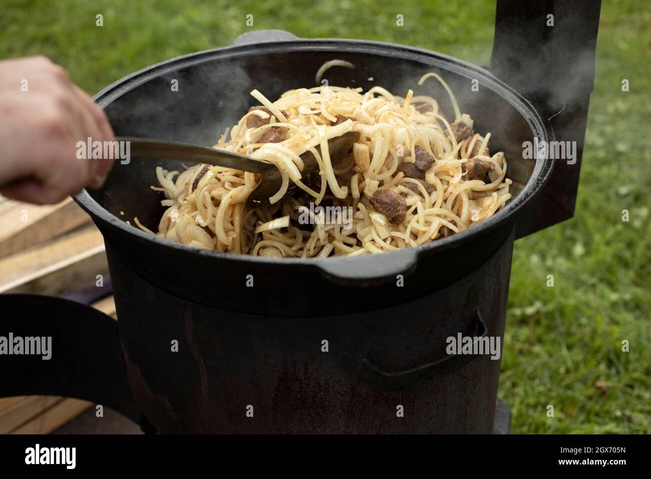 Cooking pilaf. The food is fried in a frying pan. Lunch in nature ...