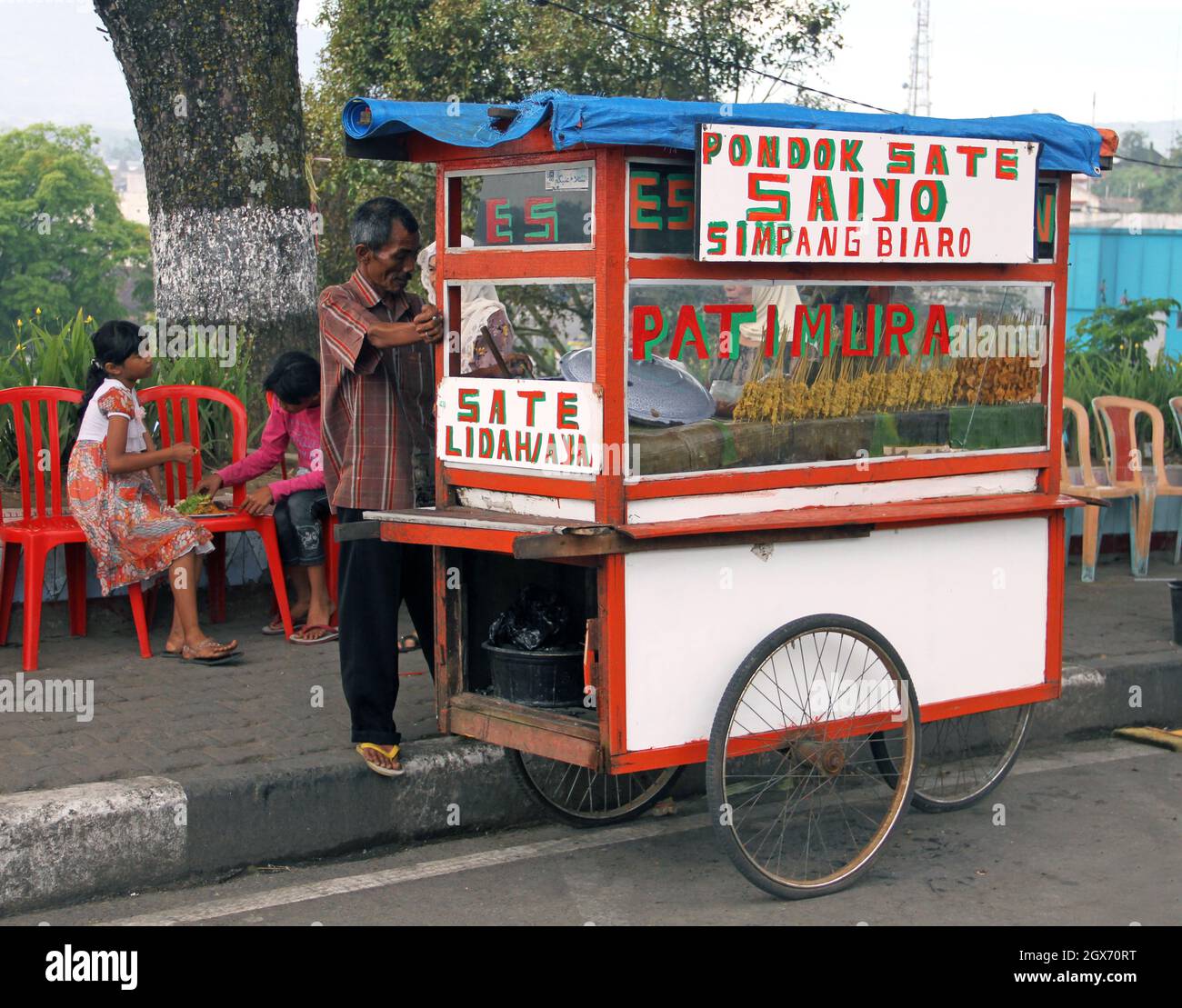 A street food vendor of chicken and goat meat sate or satay with food ...