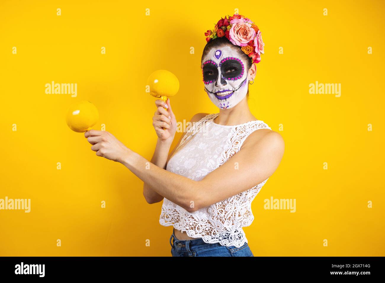 Mexican Catrina, portrait of young latin woman holding mexican maracas ...