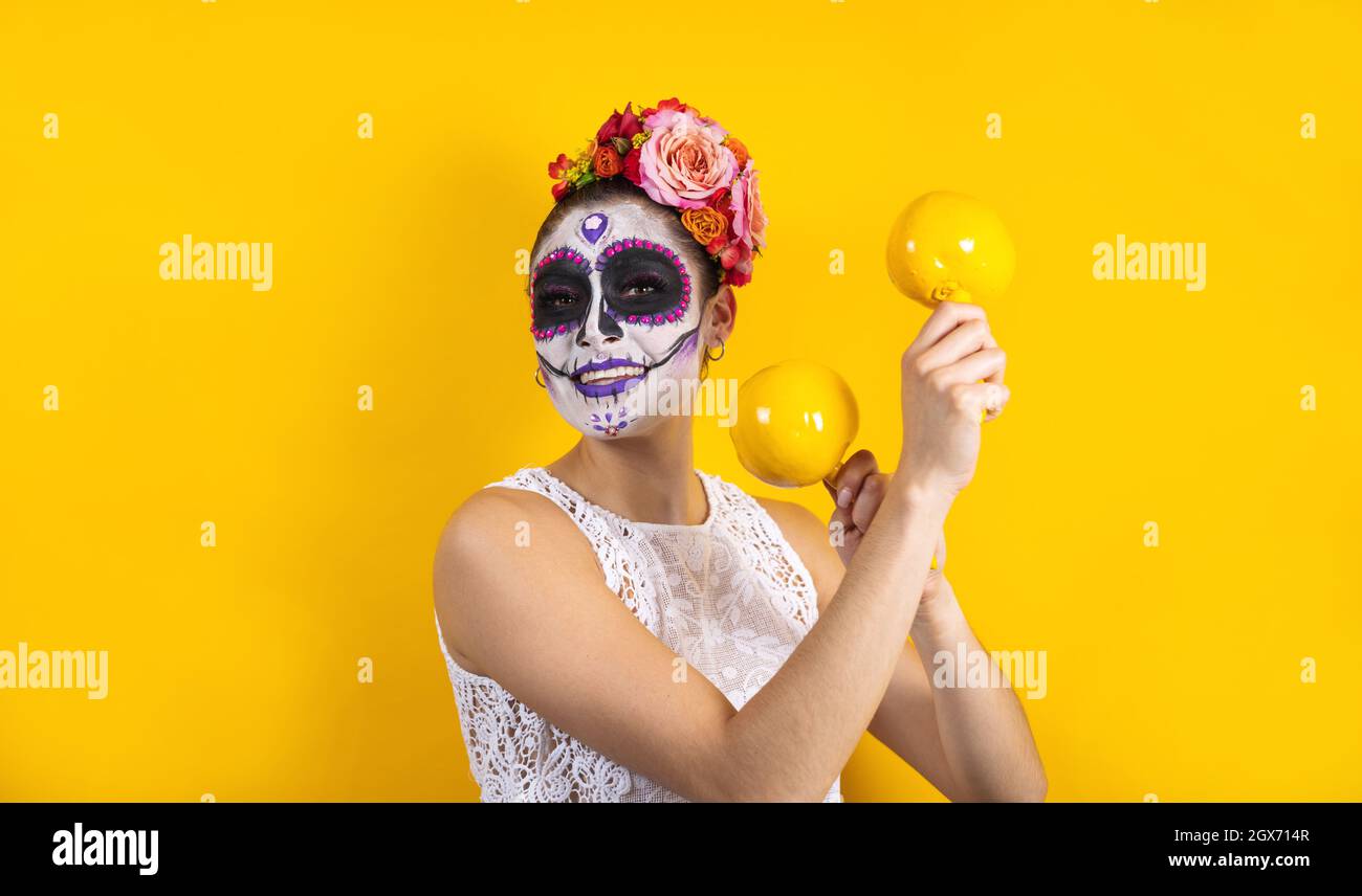 Mexican Catrina, portrait of young latin woman holding mexican maracas ...