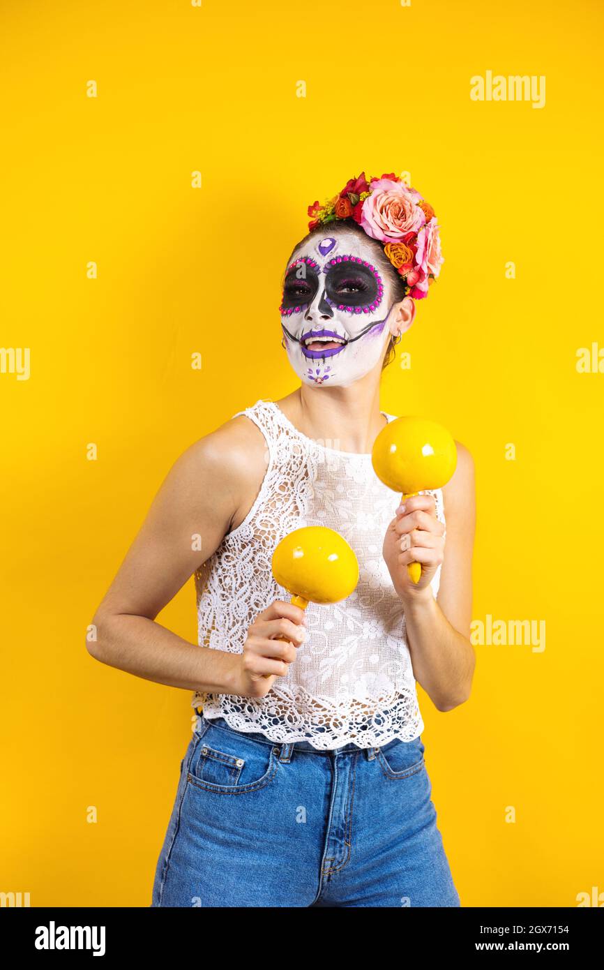 Mexican Catrina, portrait of young latin woman holding mexican maracas ...