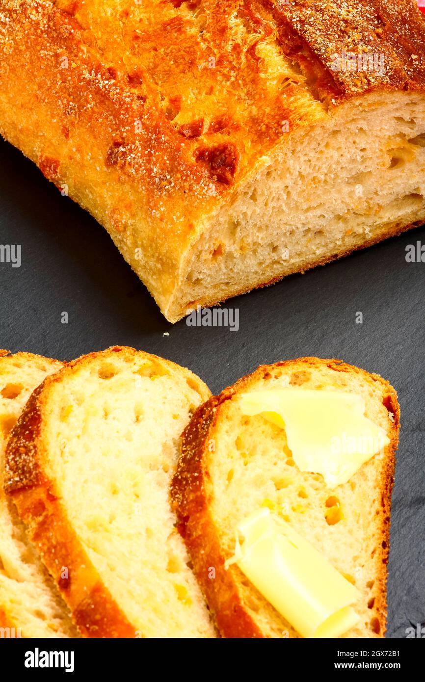 Buttered slices of sourdough bread laid on a slate serving platter ...