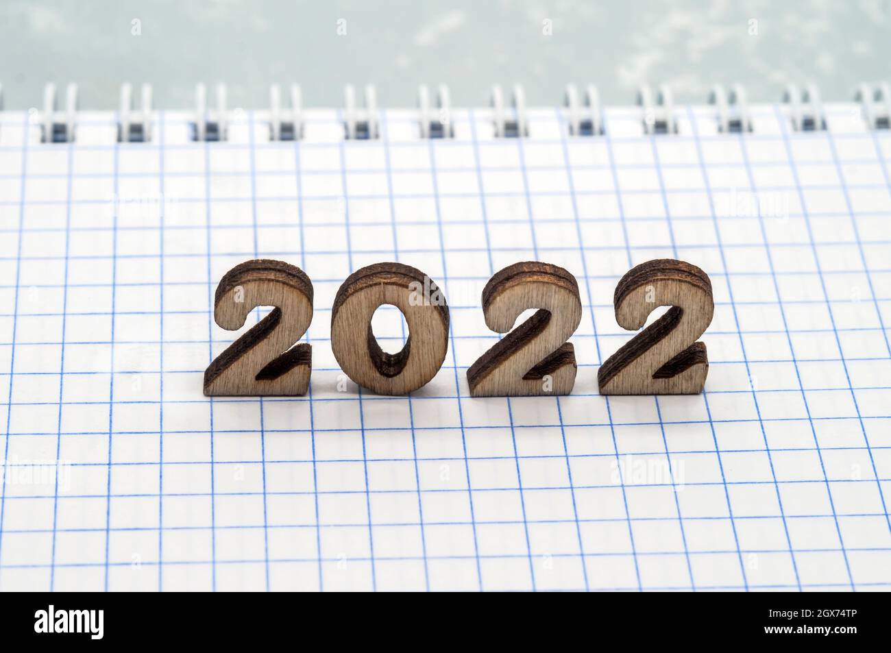 Wooden numbers date 2022. Notebook on the table. A blank sheet of paper ...