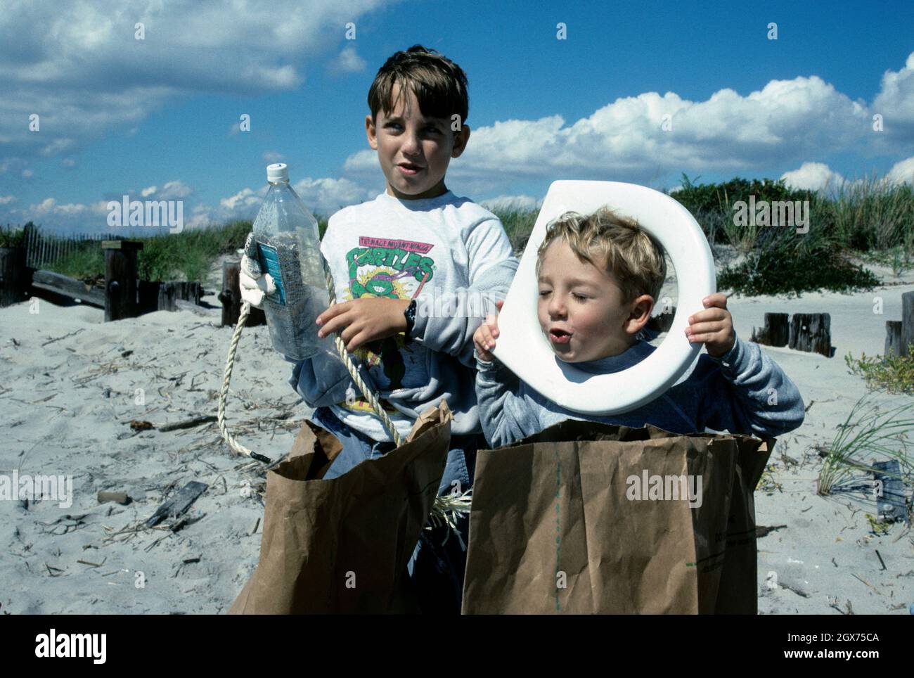 Two little boys clowning at a beach cleanup event Stock Photo - Alamy