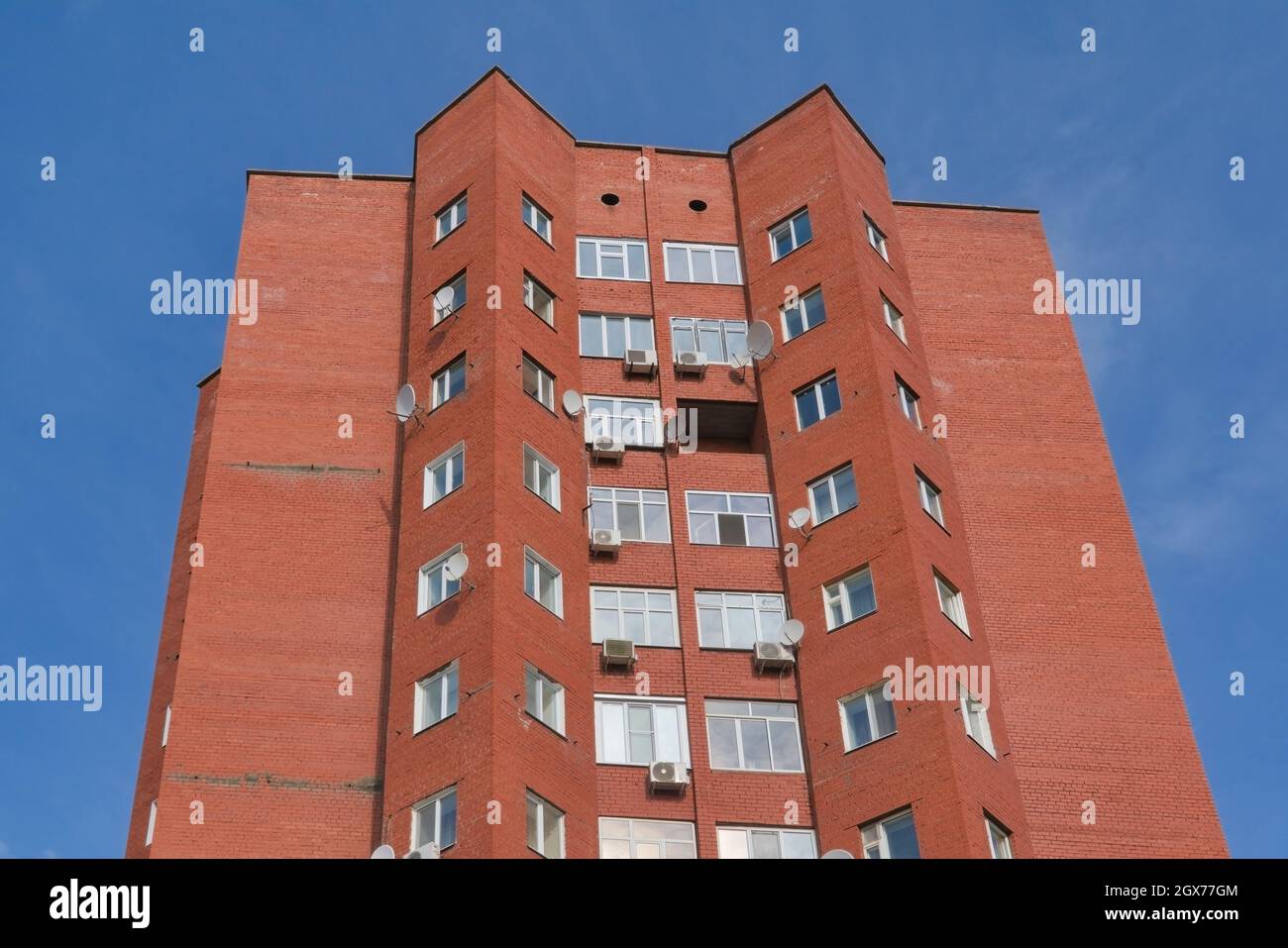 Multi-storey brick facade of house red against the blue sky Stock Photo ...