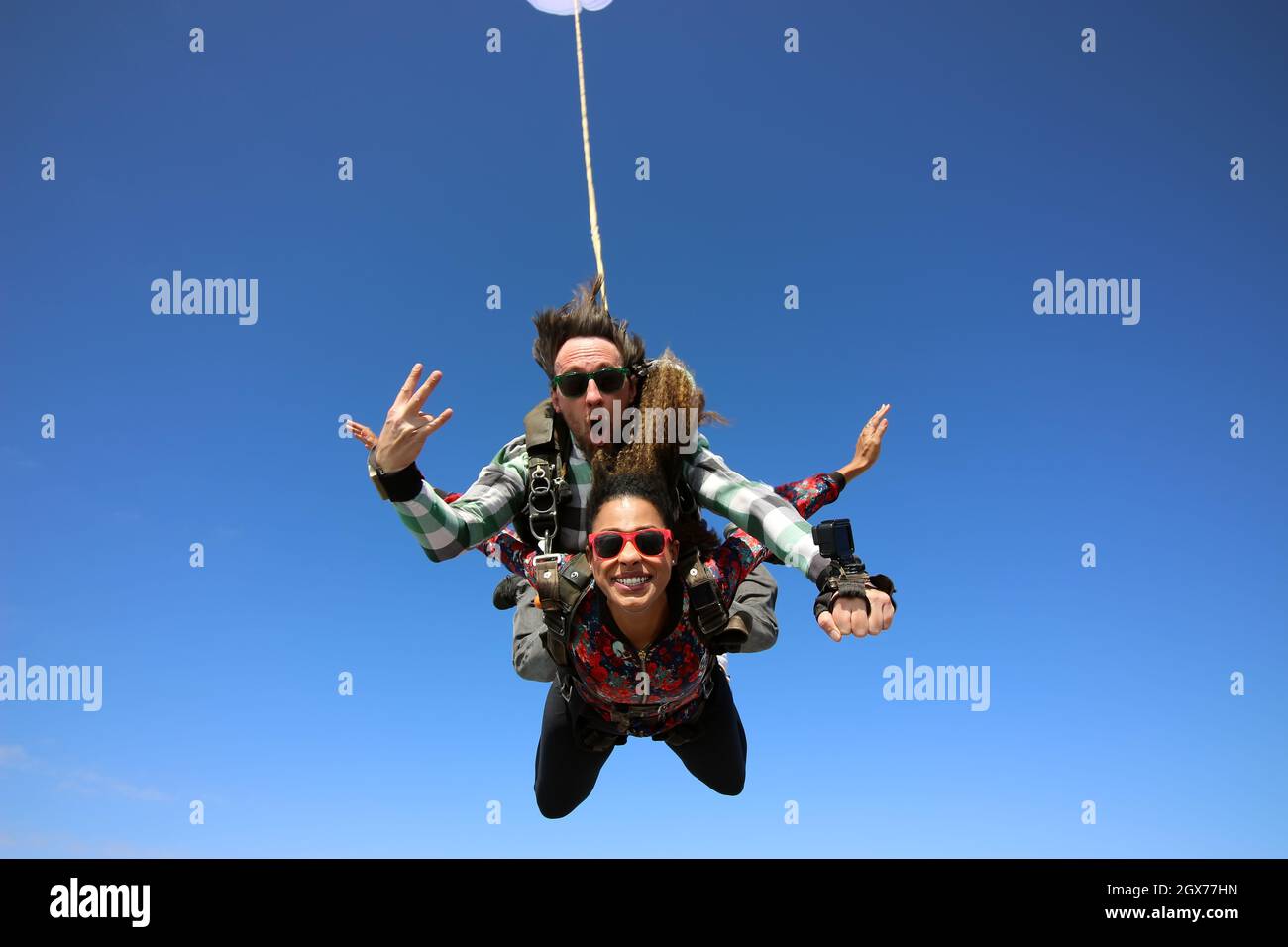 Tandem parachute jump. Beautiful Brazilian woman Stock Photo - Alamy
