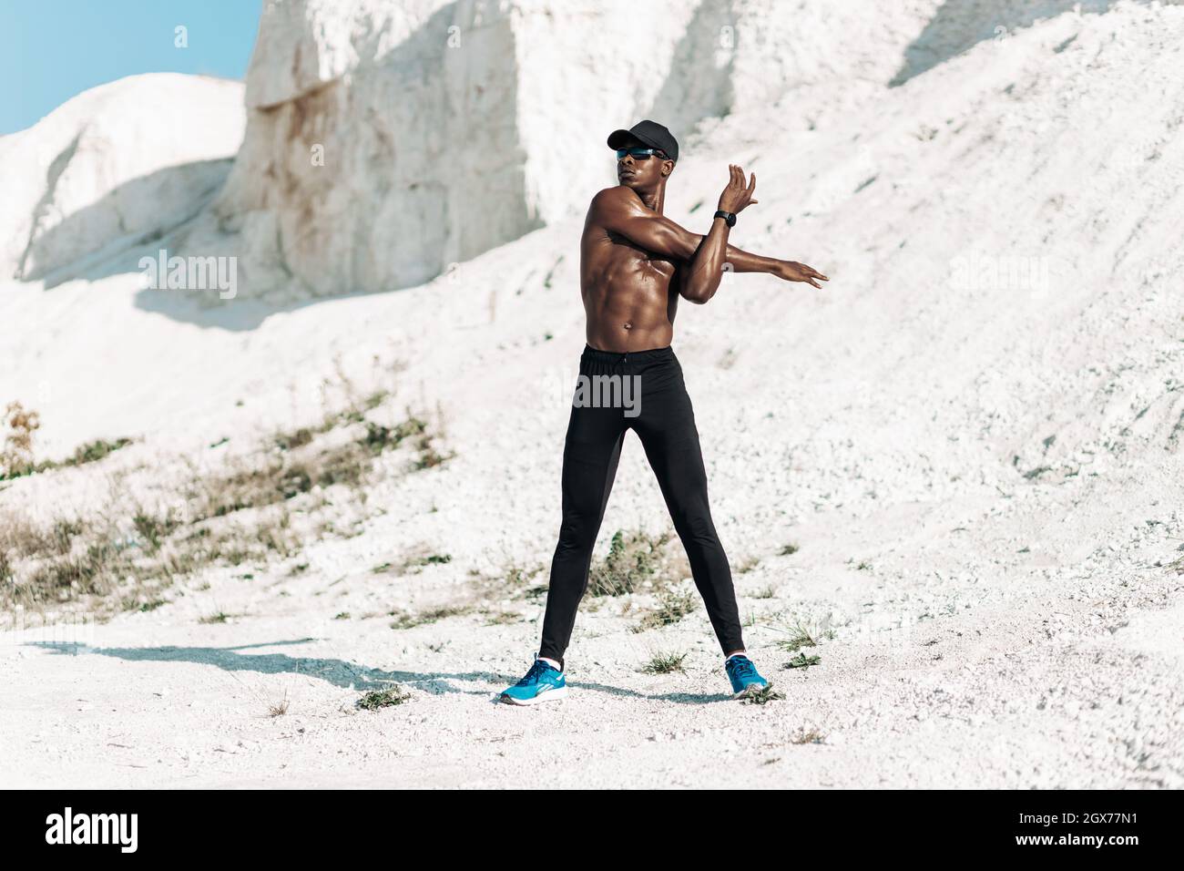 Muscular African American man doing stretching and getting ready for ...