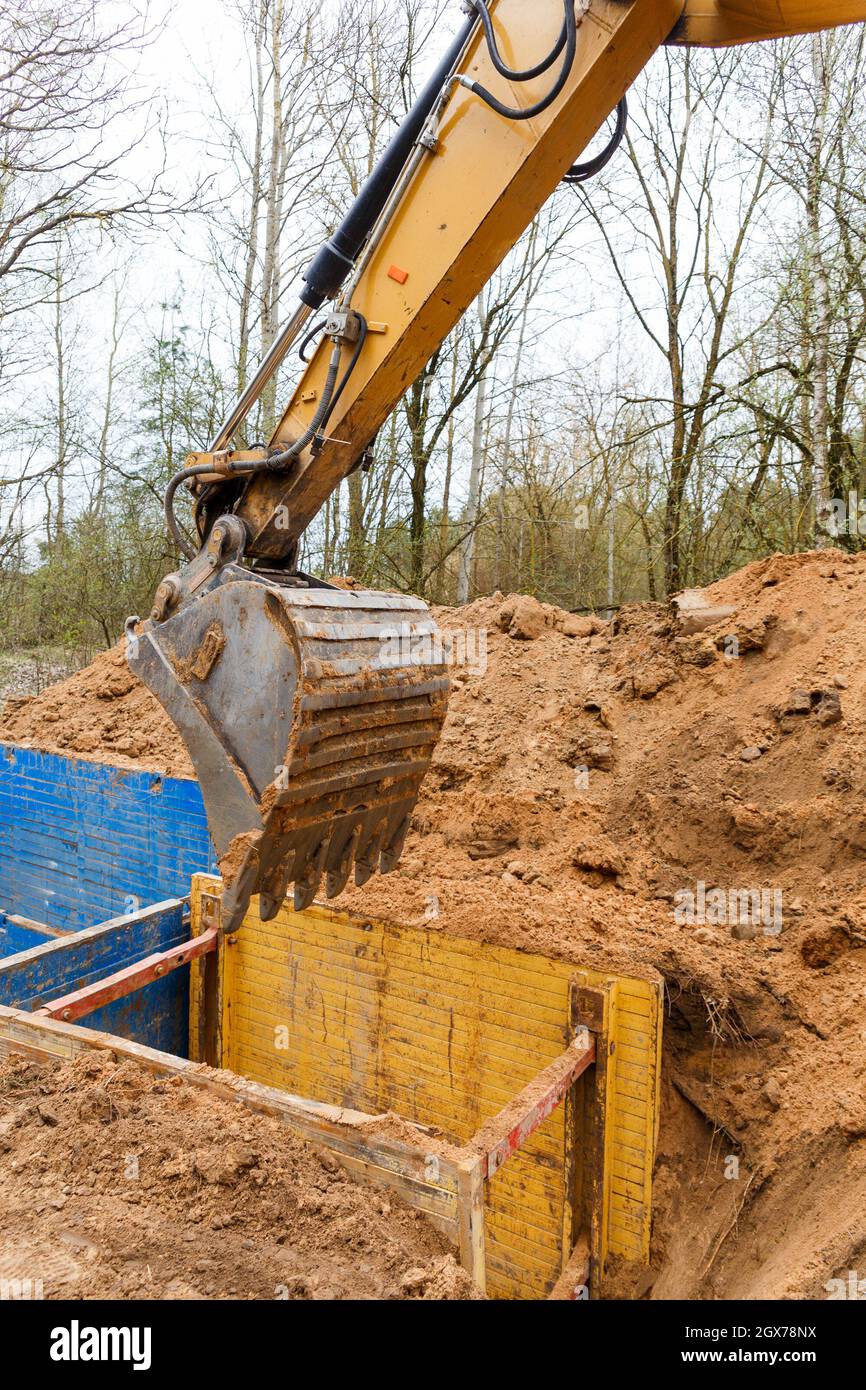 Installation of metal supports to protect the walls of the trench. The ...
