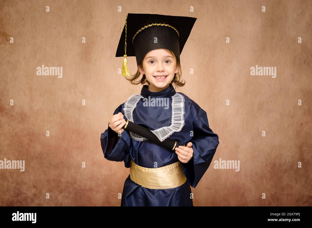 Beautiful little girl happy with her graduation. Dressed with her ...